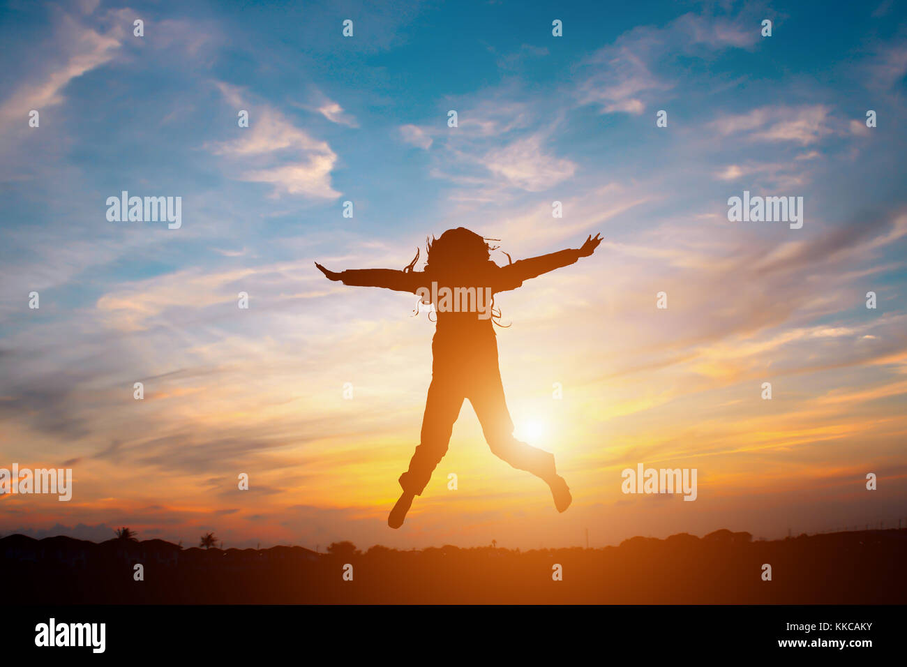 Happy businesswoman jumping in sunset sky Stock Photo - Alamy