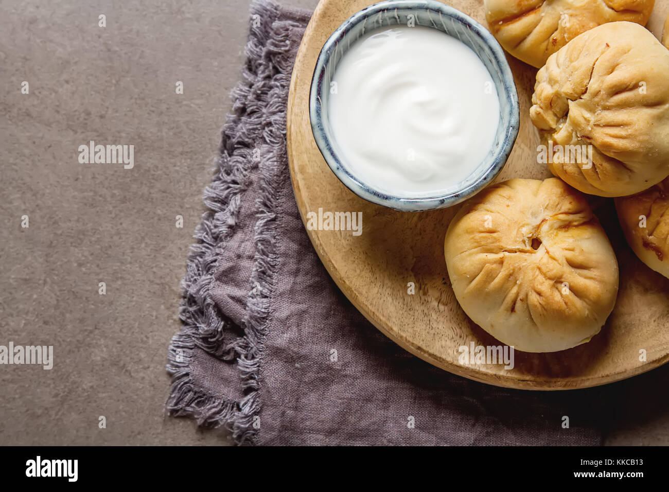 Traditional Russian meat pie, (belyashi) with sour cream. Dark ...