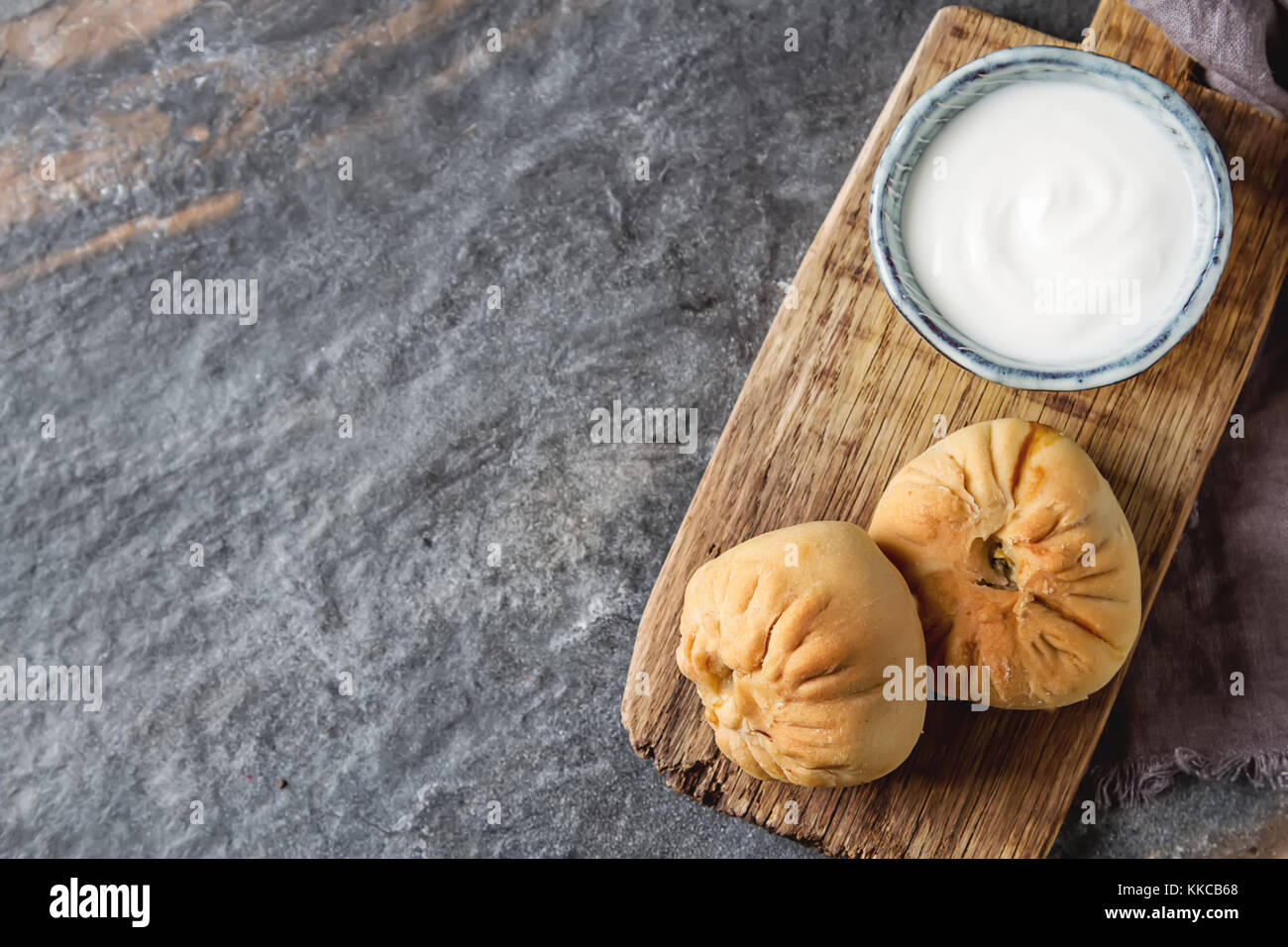 Traditional Russian meat pie, (belyashi) with sour cream. Dark ...