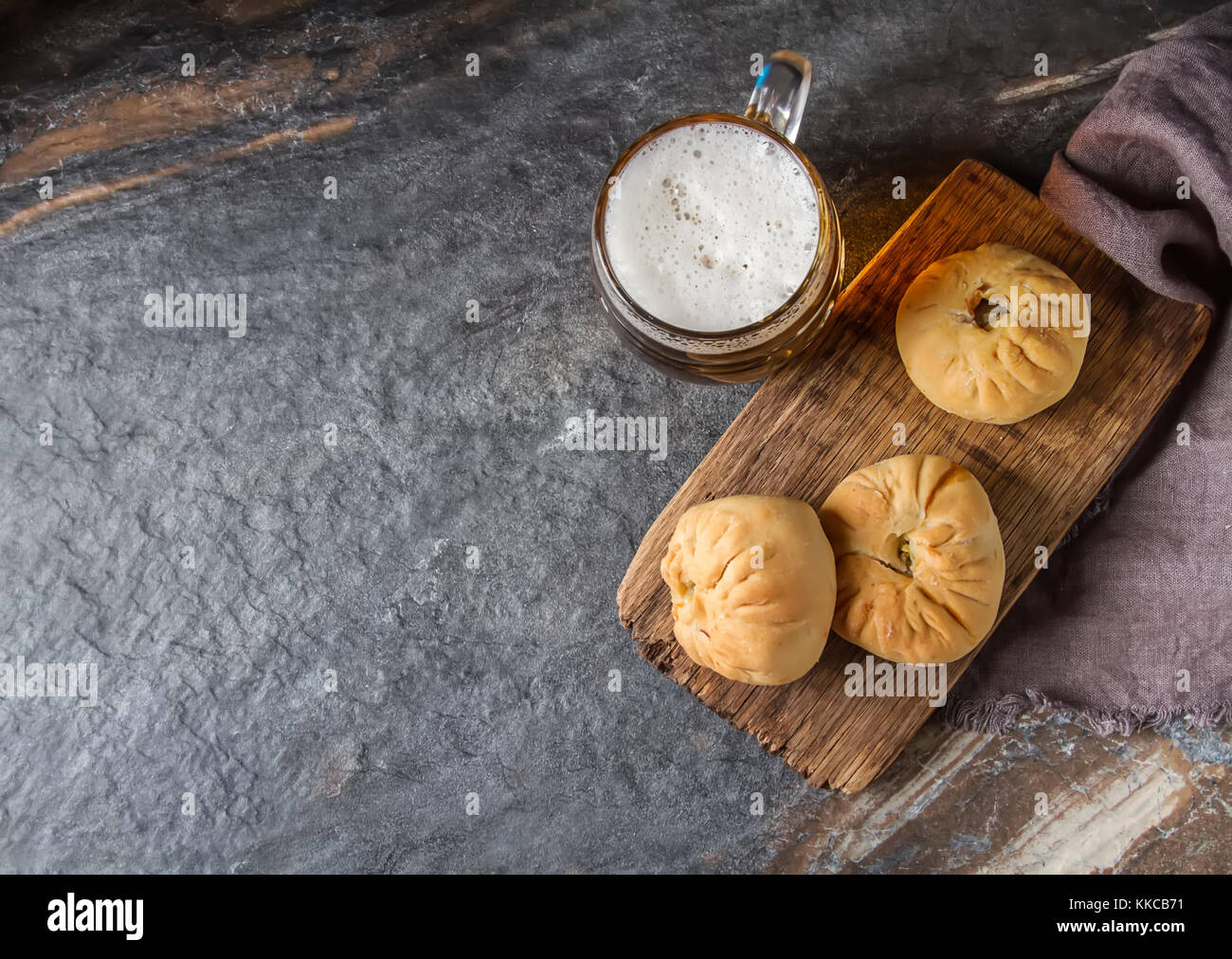 Traditional Russian meat pie, (belyashi) with beer. Dark background ...