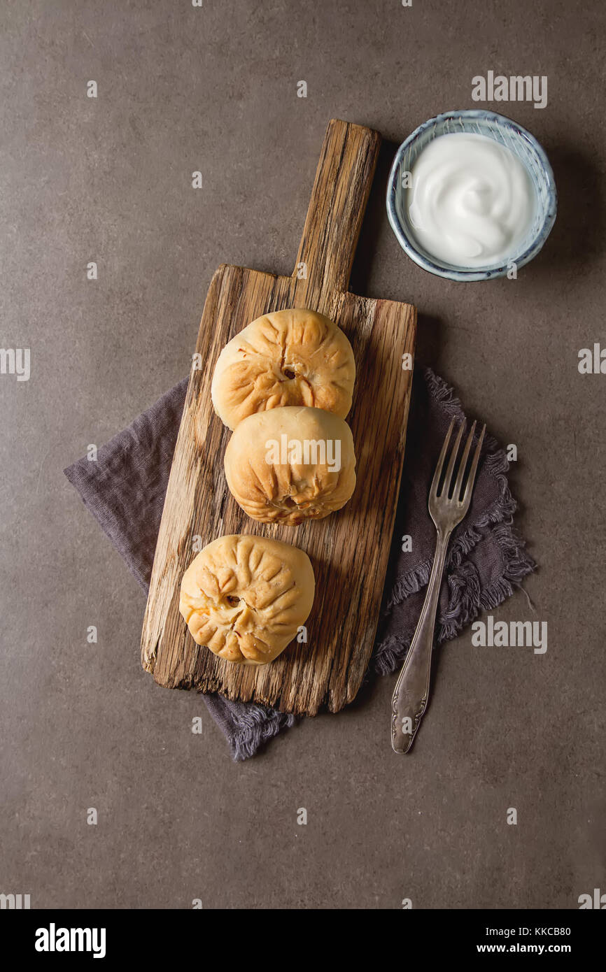 Traditional Russian meat pie, (belyashi) with sour cream. Dark ...