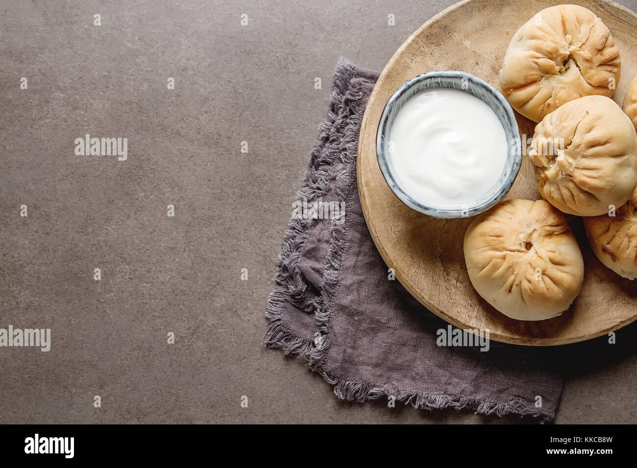 Traditional Russian meat pie, (belyashi) with sour cream. Dark ...
