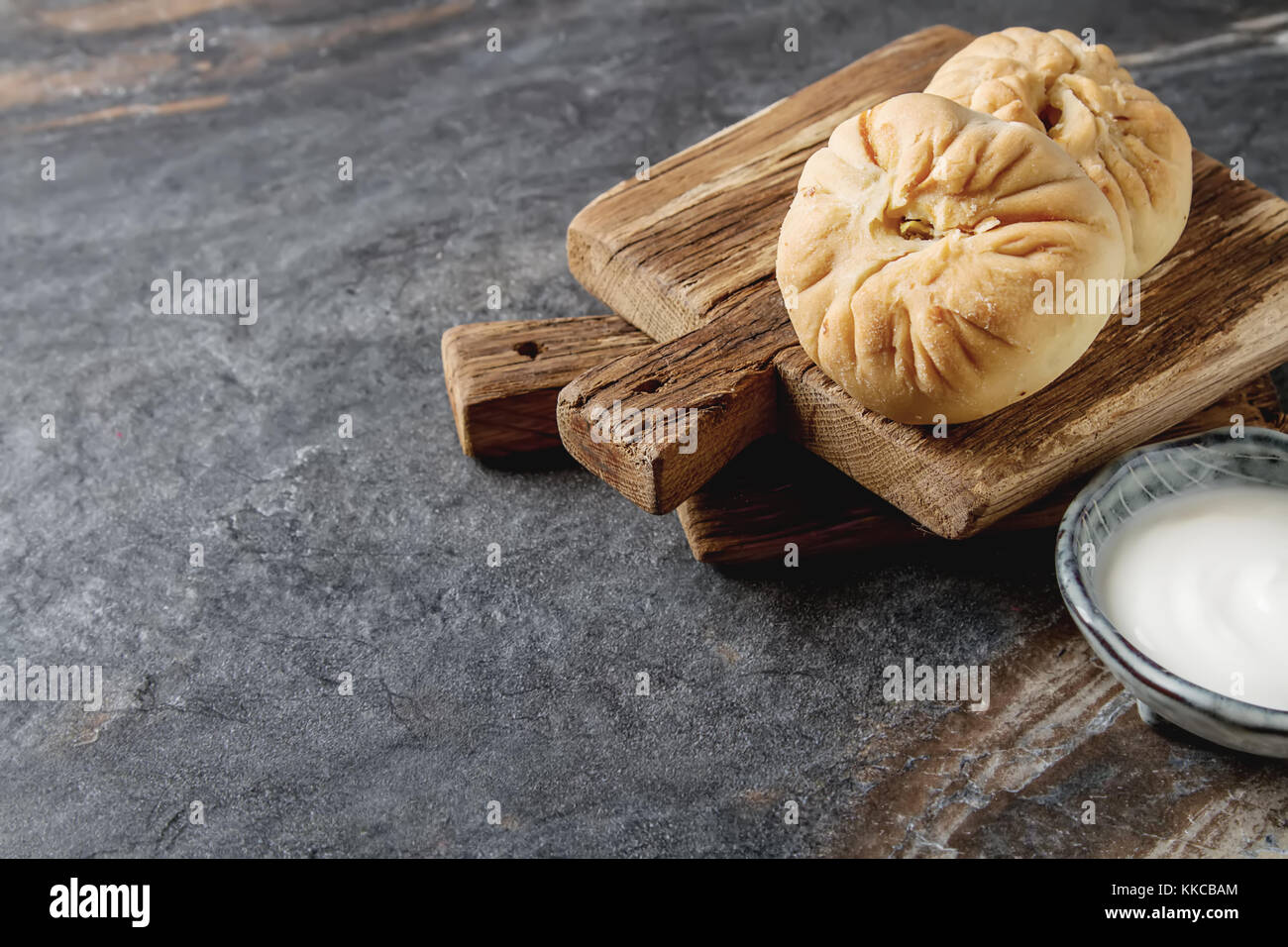 Traditional Russian meat pie, (belyashi) with sour cream. Dark ...