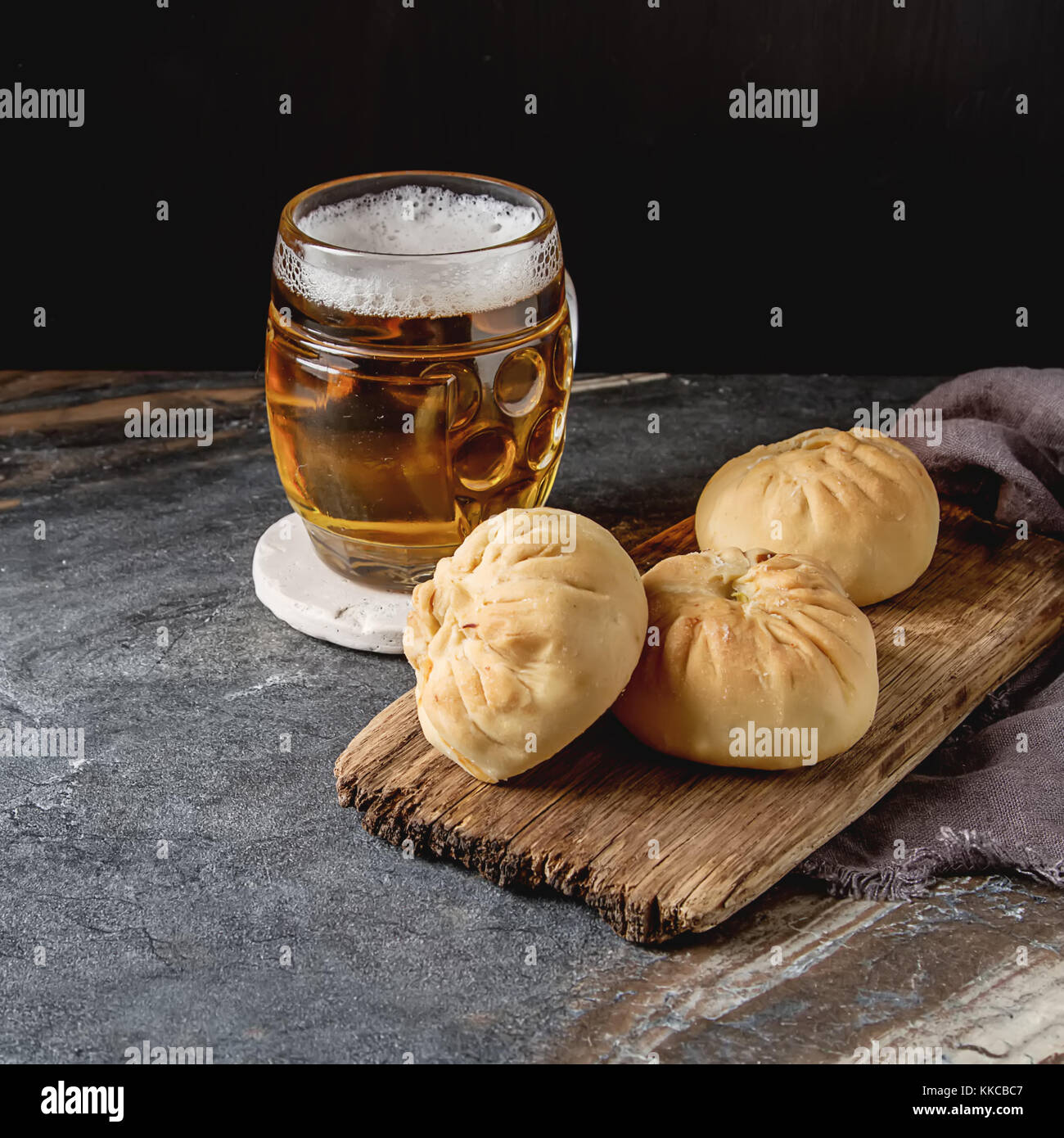 Traditional Russian meat pie, (belyashi) with beer. Dark background ...