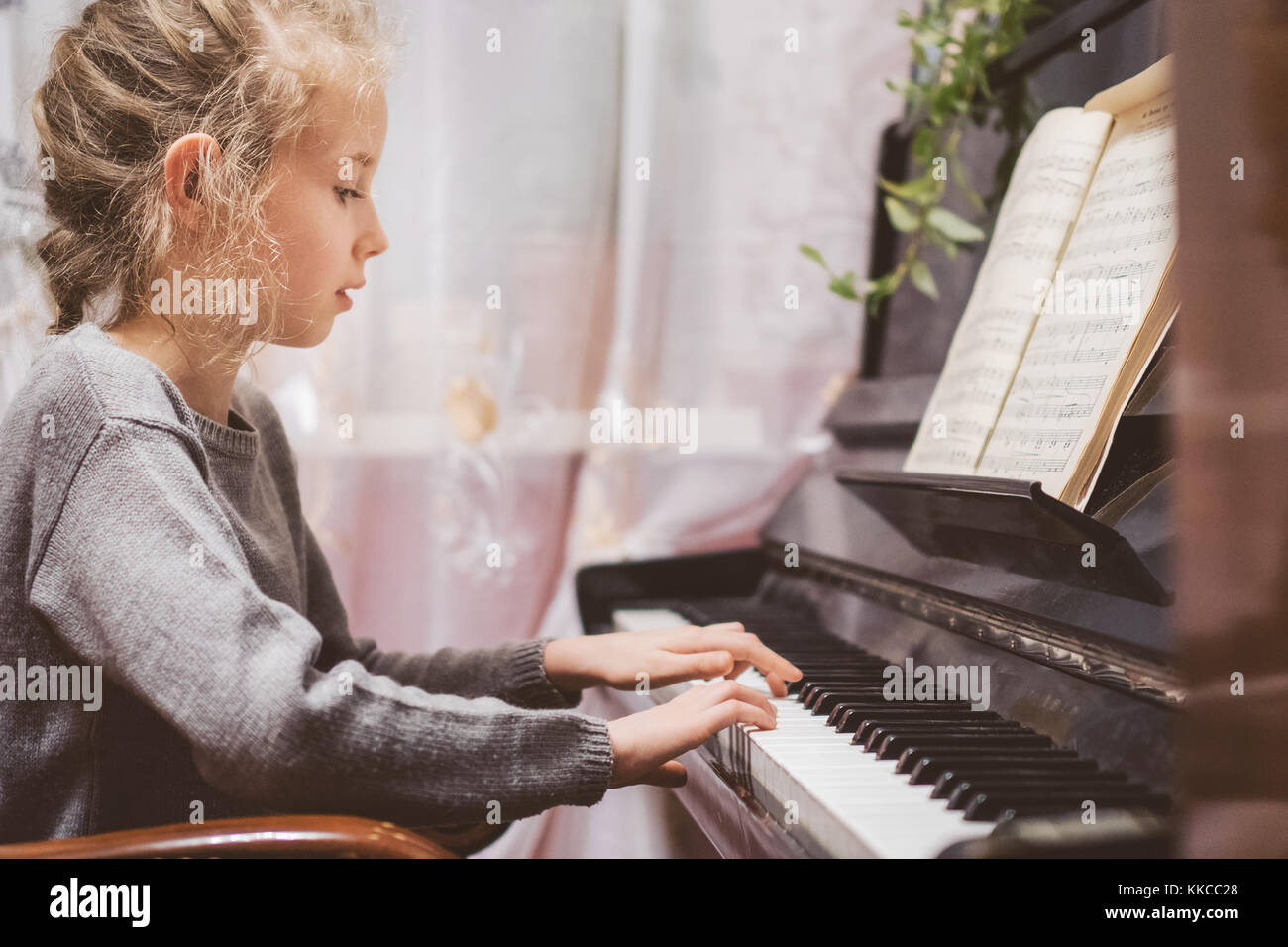 Little girl learning to play the piano Stock Photo - Alamy
