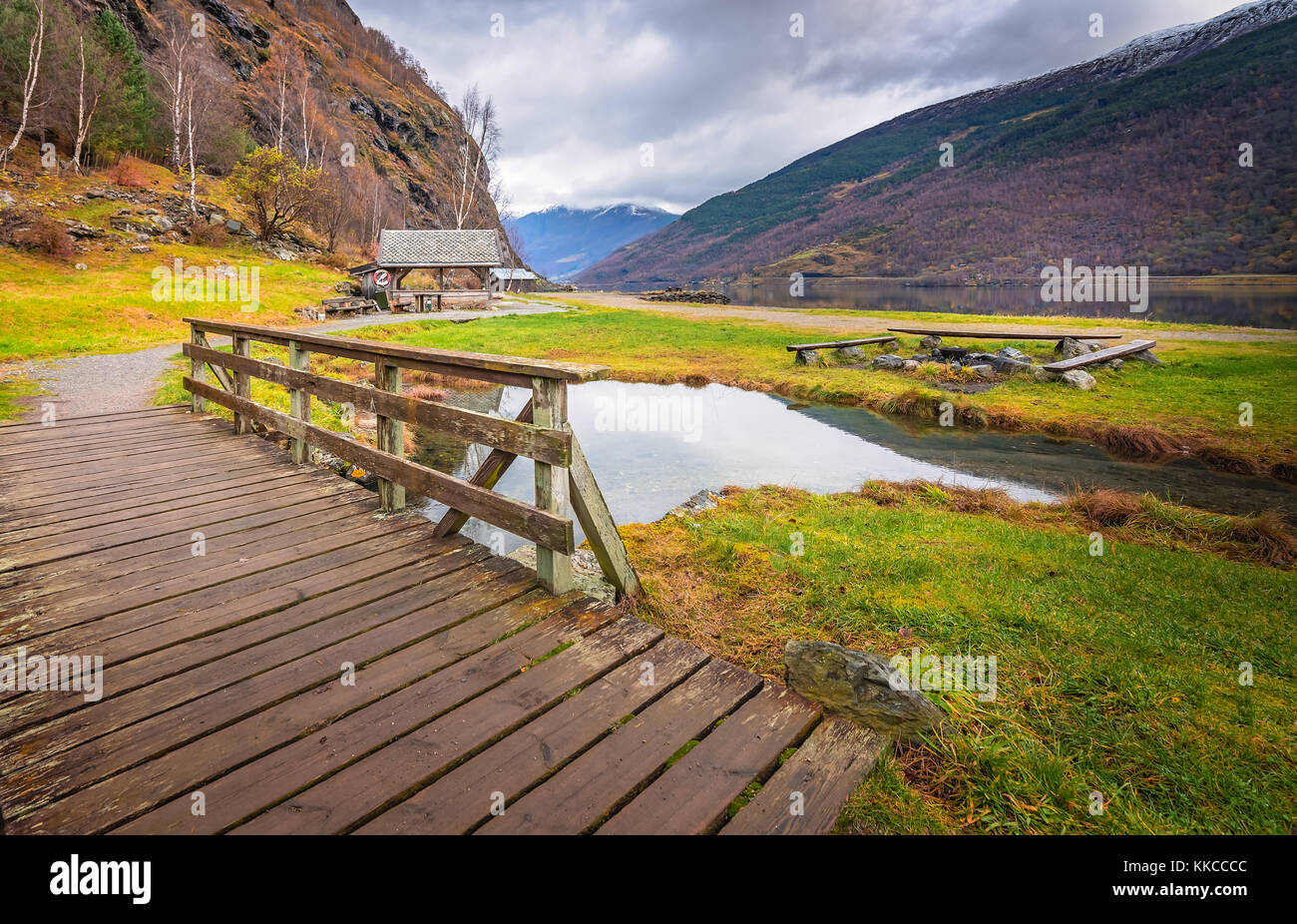 Small wooden bridge on a path leading to the fjord shore in small ...