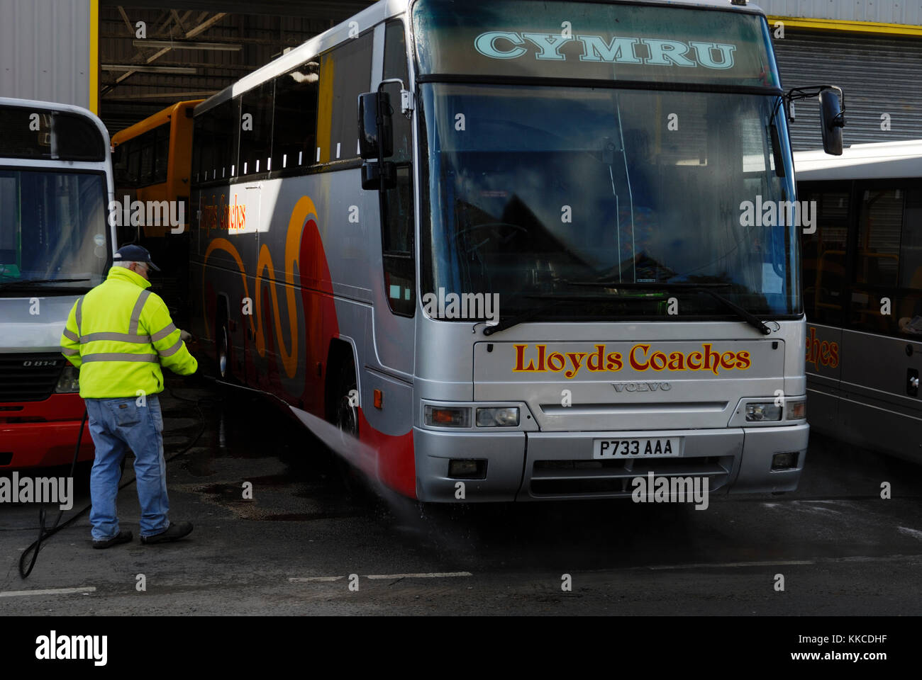 Man washing a coach with a jet sprayer, Wales Stock Photo - Alamy