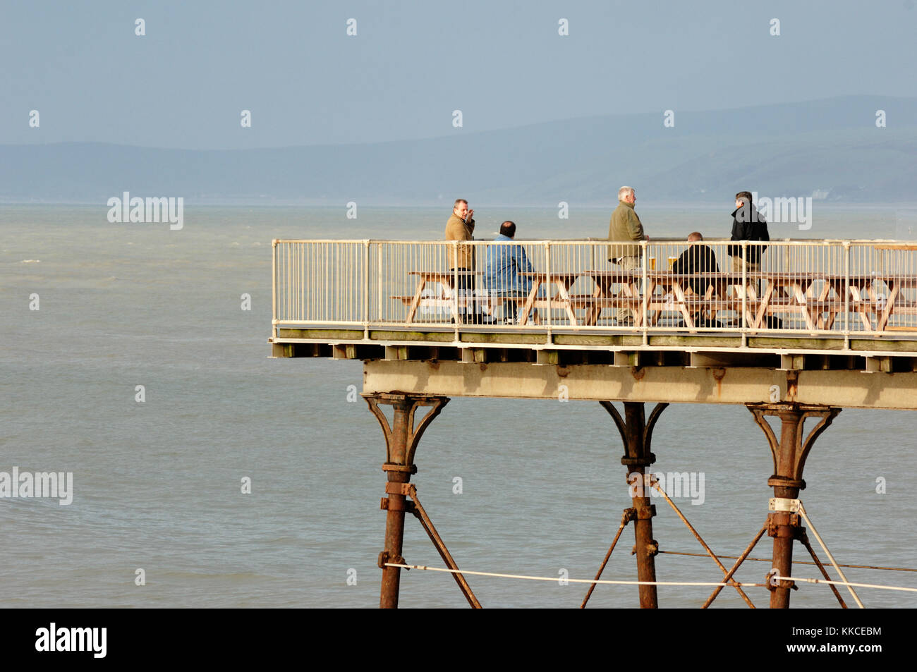Middle aged men drinking pints of lager at the end of Aberystwyth Pier ...
