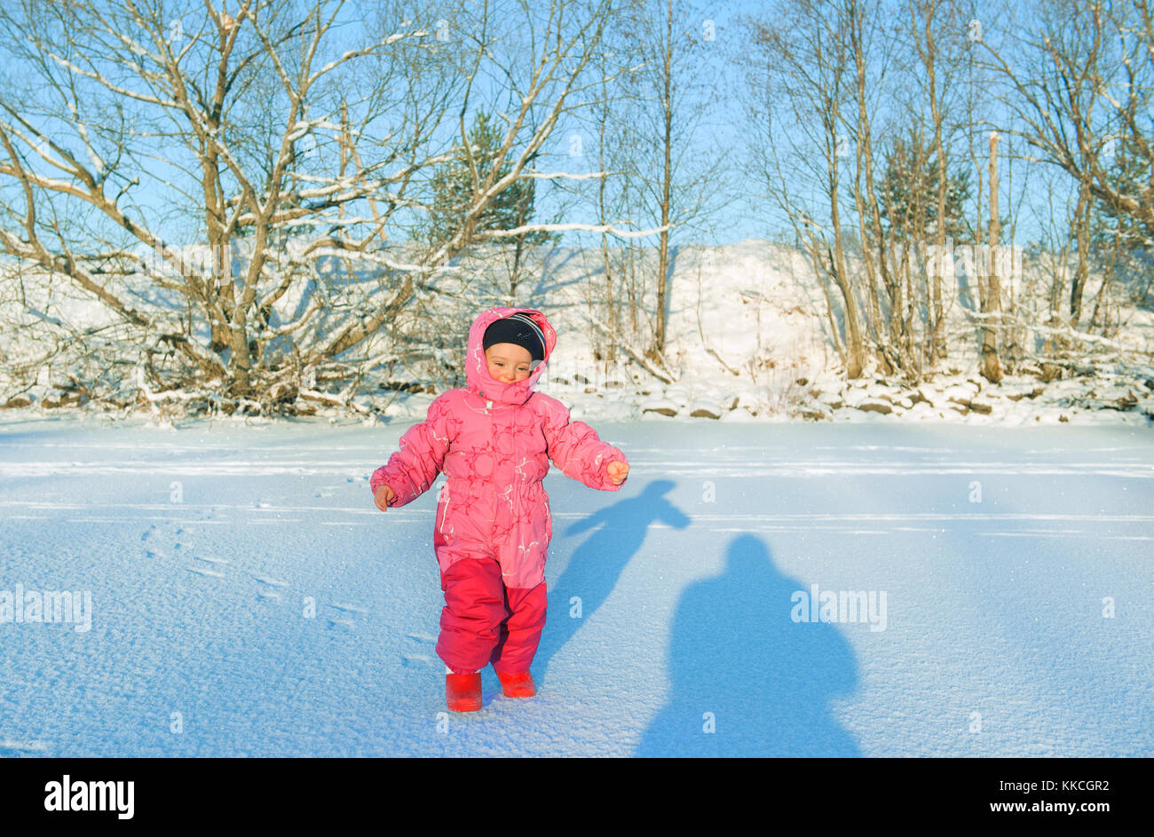 Baby girl on the snow. Little winter baby girl in fairy snowy sunny day ...