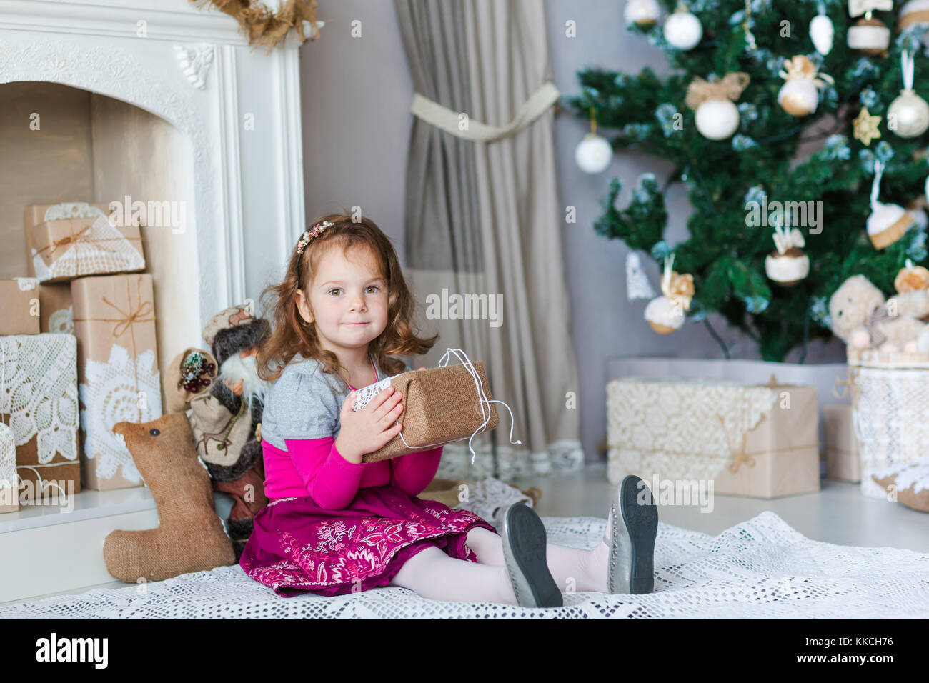 Happy little girl near Xmas tree Stock Photo - Alamy