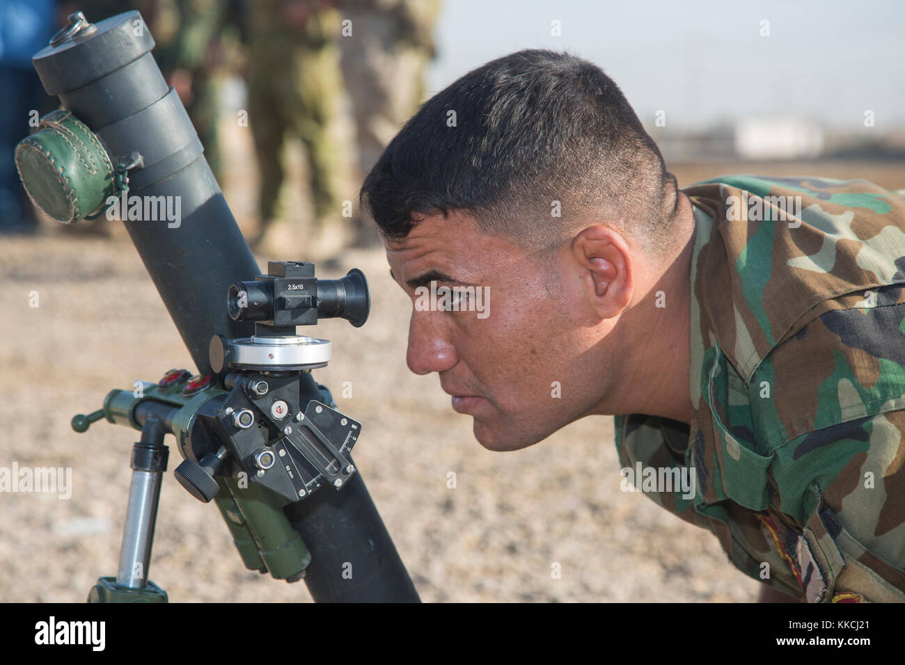 An Iraqi security forces member looks through the viewfinder at a ...