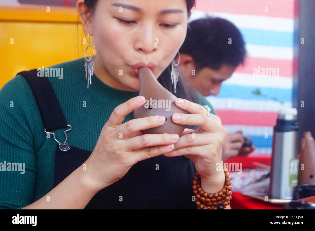 A young woman was playing an old musical instrument with her mouth ...