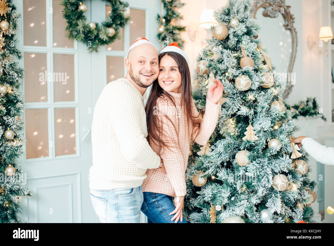 Cute, young couple decorating a Christmas tree Stock Photo - Alamy