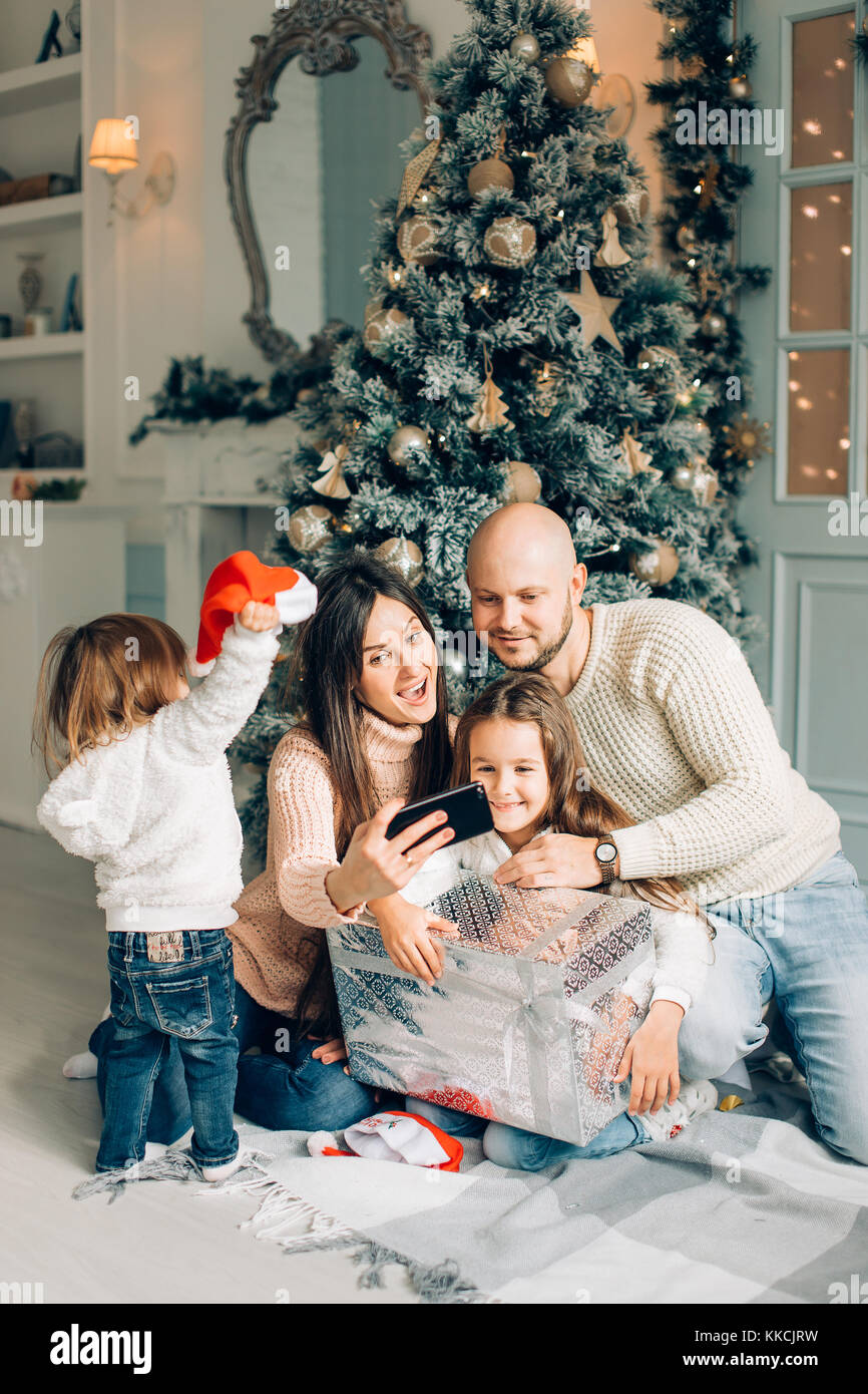 miling young family in Christmas atmosphere making photo with ...