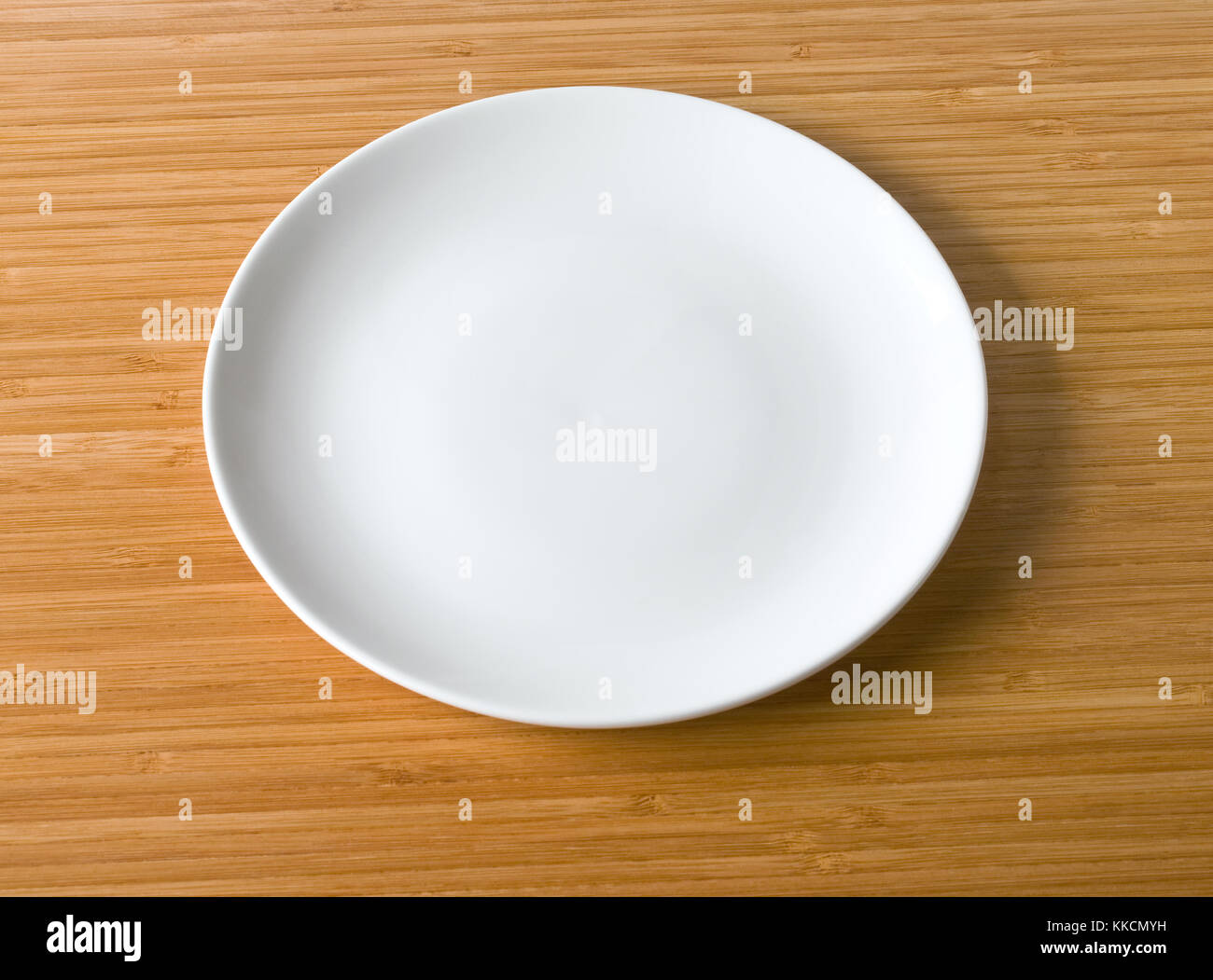 white empty platel on a bamboo table top Stock Photo - Alamy