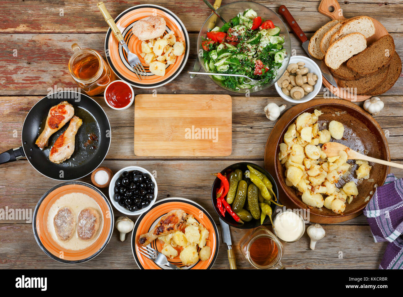 Dining table with a variety of dishes, grilled chicken legs, fried ...