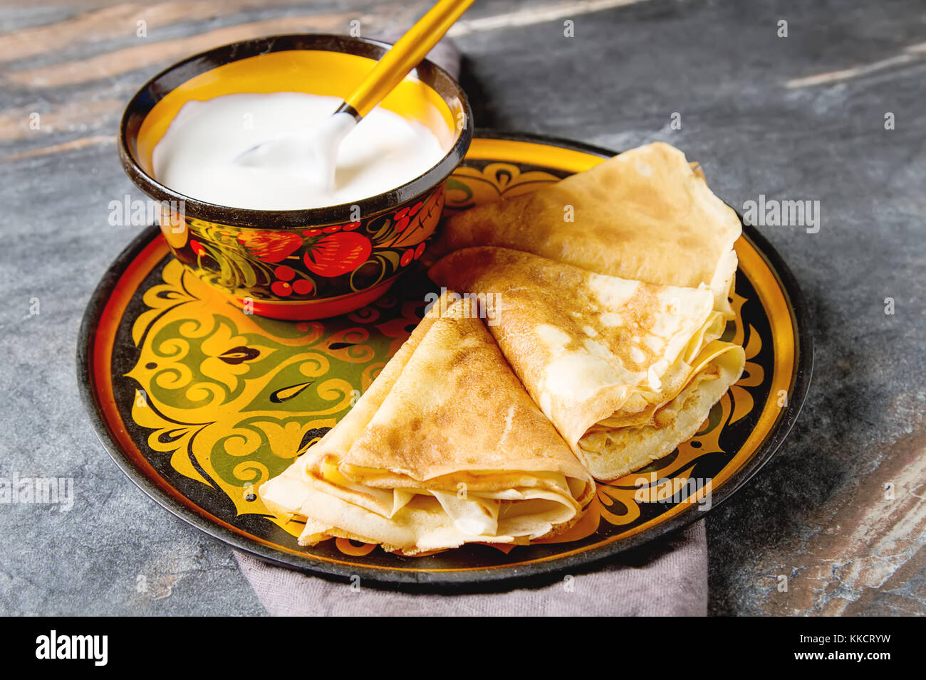 Stack of pancakes on a plate with sour cream. Traditional for the ...