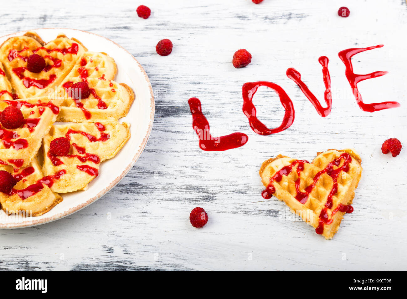 Belgian heart shaped waffle on white background. Word love made by jam ...