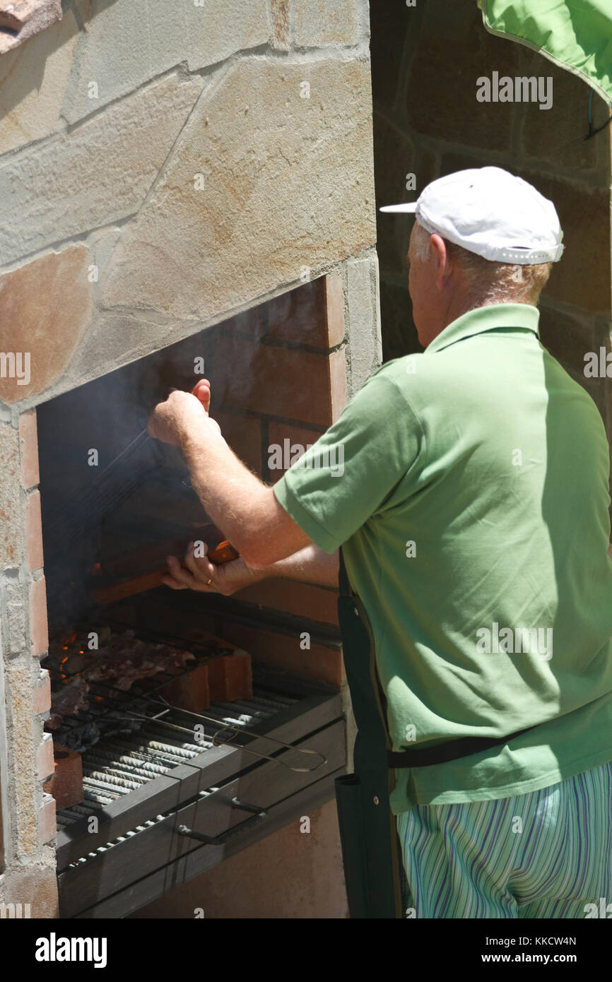 Senior man doing barbecue outdoors at beauty barbecue grill Stock Photo ...