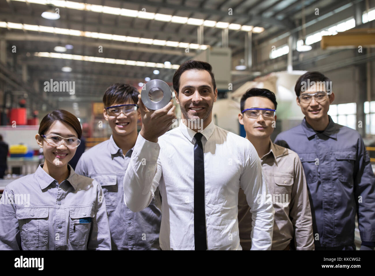 Confident businessman and engineering team in the factory Stock Photo ...