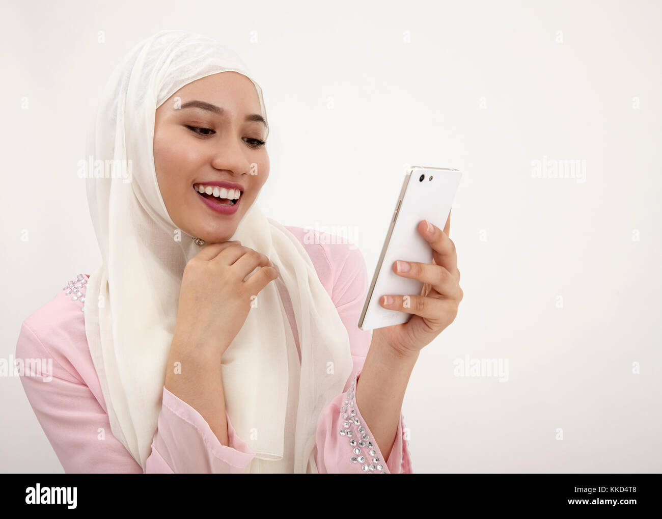 malay woman with tudung reading a message on cell phone Stock Photo - Alamy