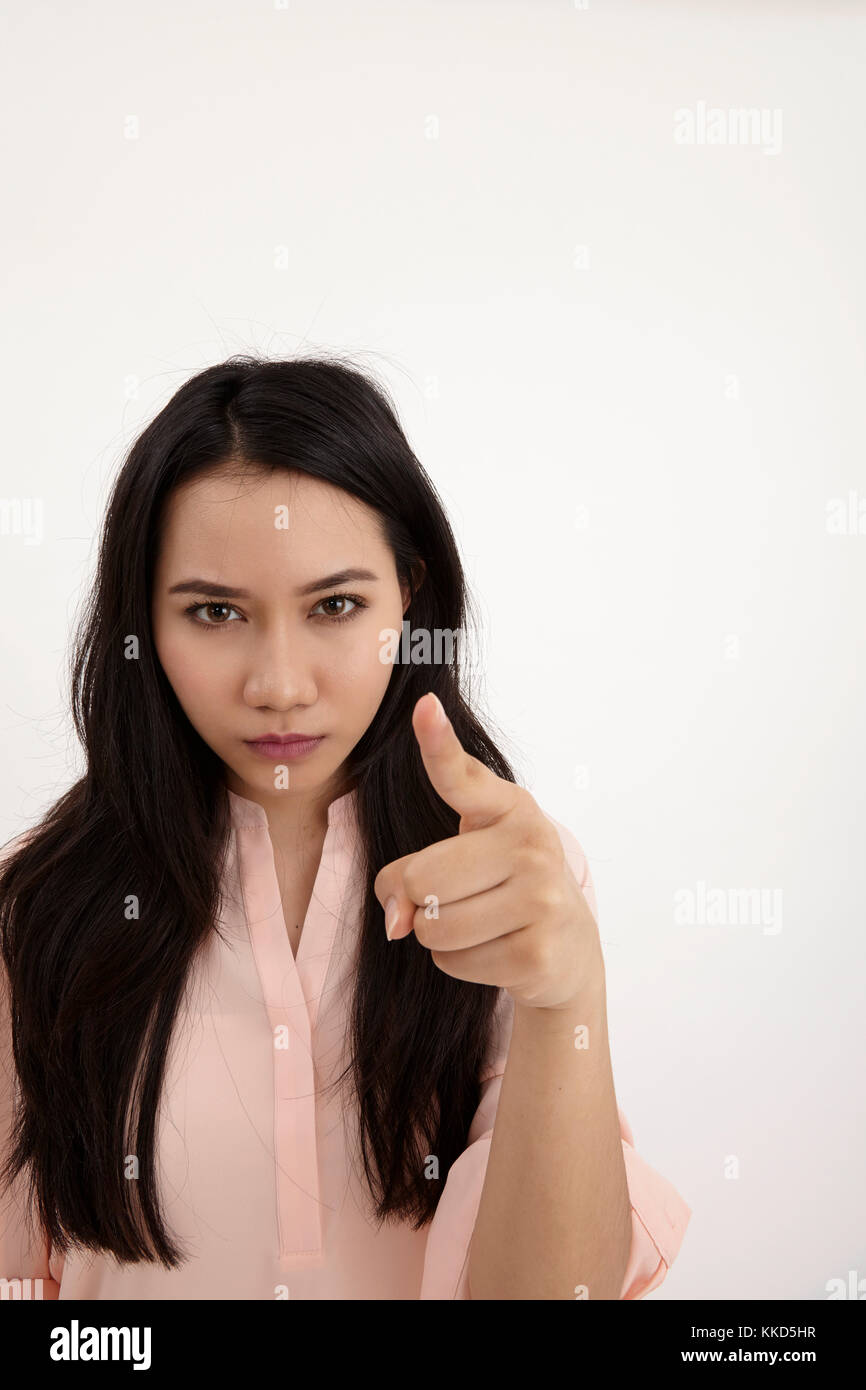 Portrait of a young angry woman pointing finger at camera isolated on a ...