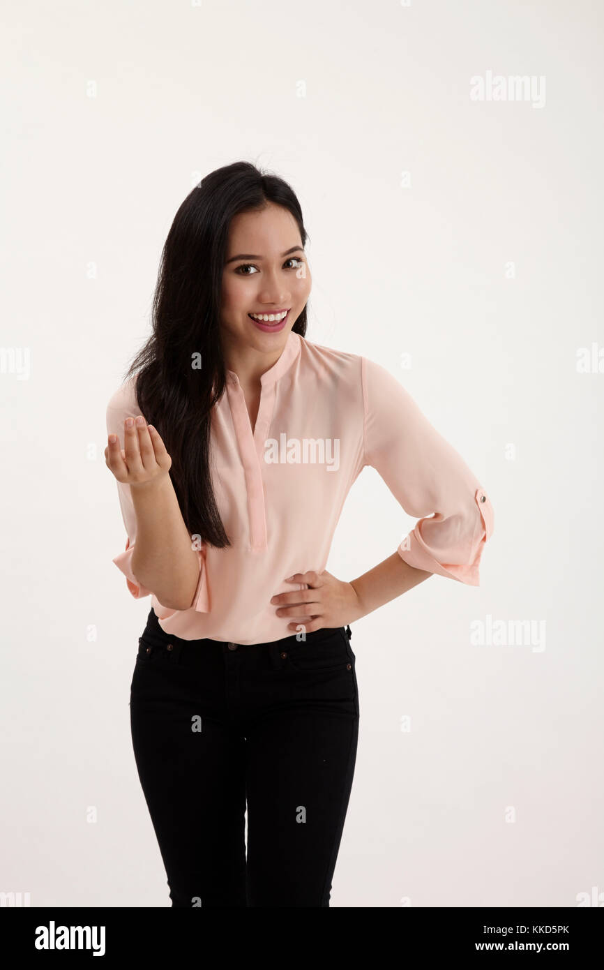 malay woman smiling with hand gesture inviting Stock Photo - Alamy