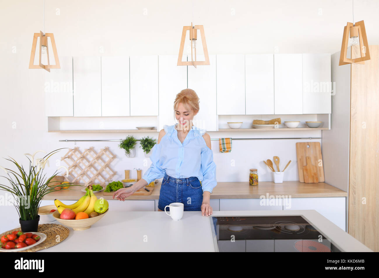 Pretty girl walks into kitchen and stretches, enjoying morning c Stock ...