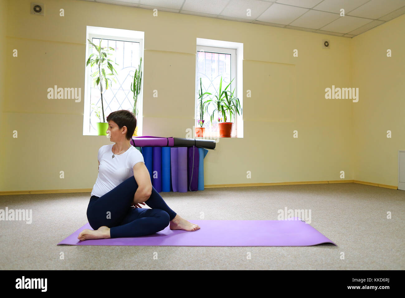 Young beautiful woman sitting on floor on mat for fitness and pe Stock ...