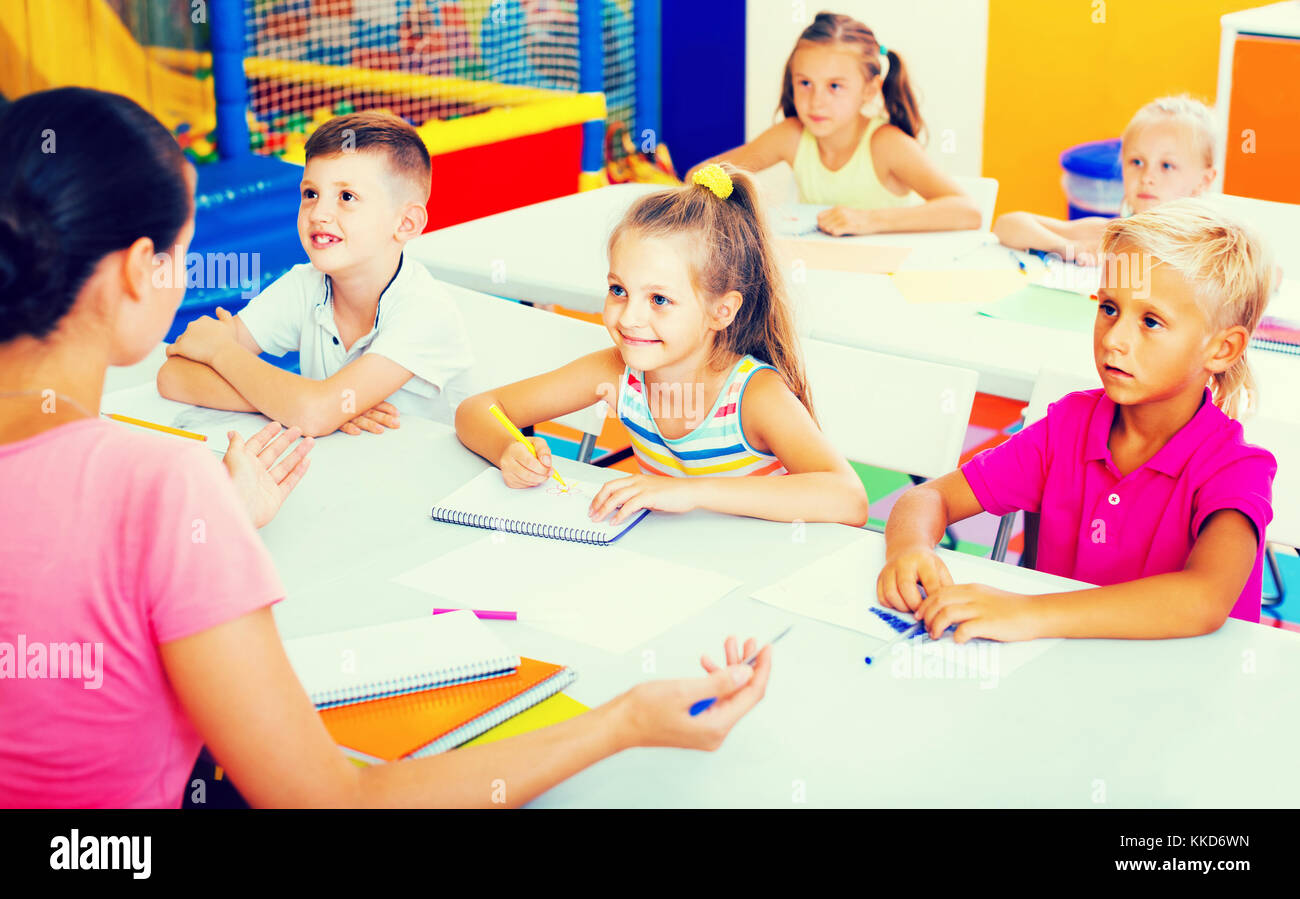 american children sitting together and studying in class at school ...