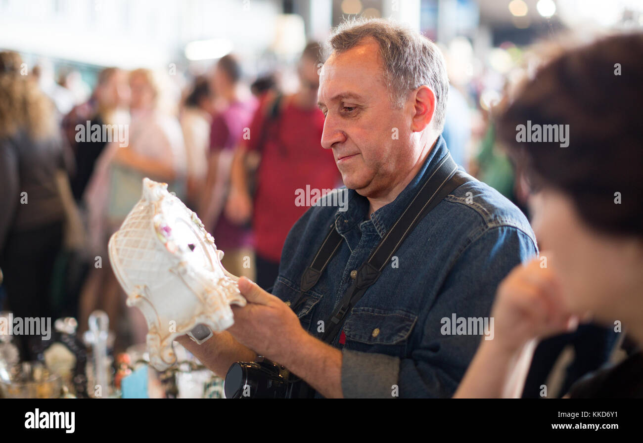 two people aged consider things in flea market Stock Photo - Alamy