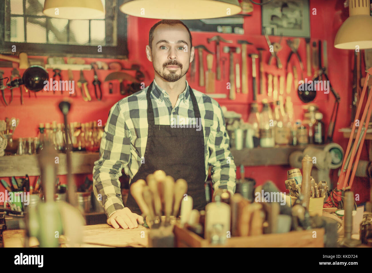 Positive smiling efficient male worker demonstrating workplace and ...