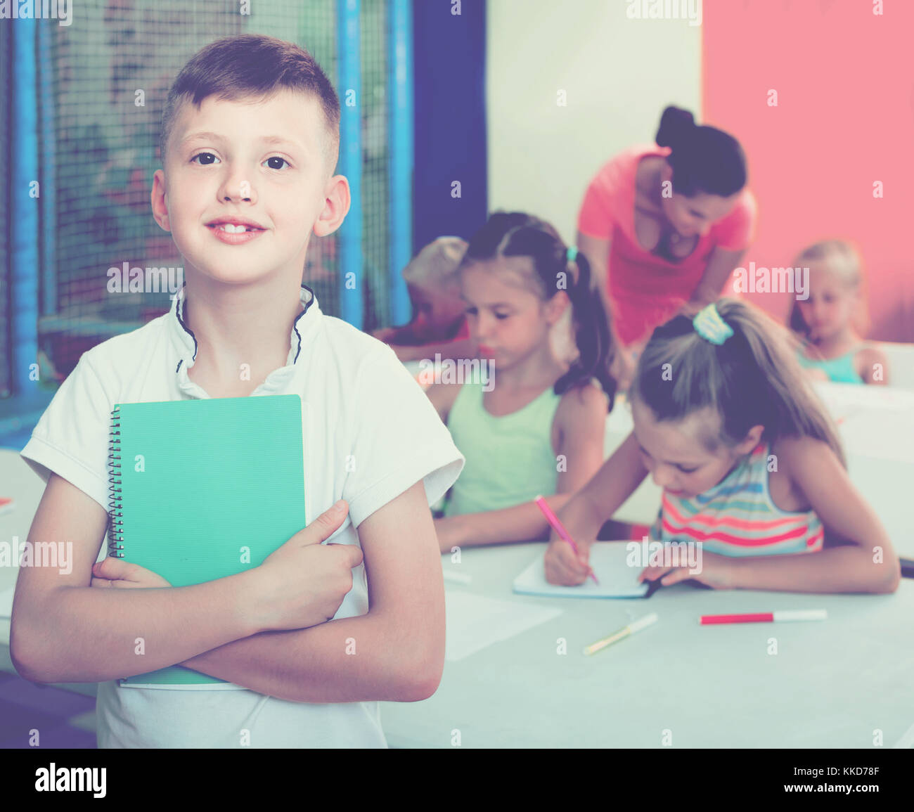 Portrait of cheerful russian boy holding notepad in school class Stock ...