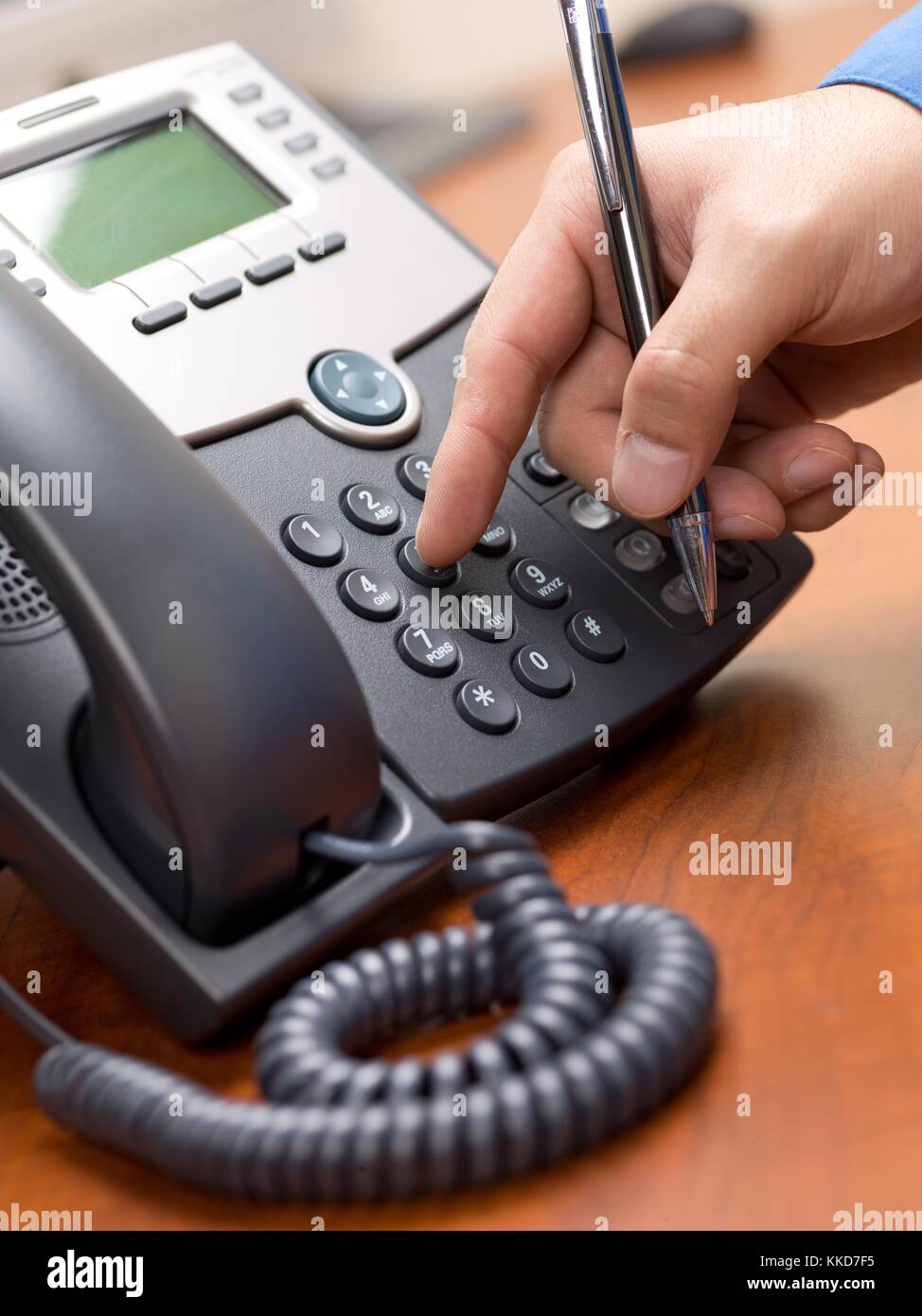 cropped image of a person dialing number on landline phone Stock Photo ...