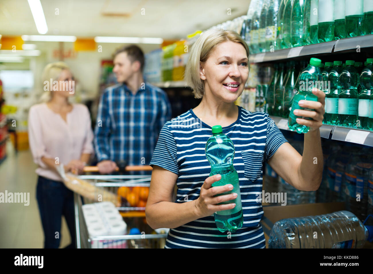 Happy female customers purchasing mineral water in the hypermarket ...