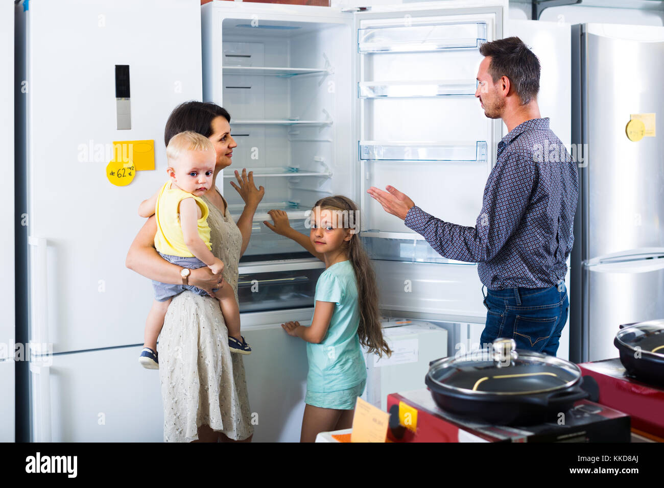 smiling family with two children choosing new fridge for kitchen Stock ...