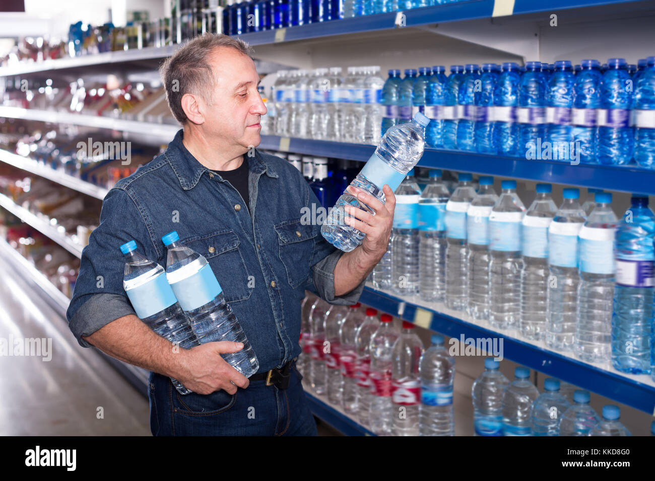 Portrait of glad man buying a water at the grocery store Stock Photo ...