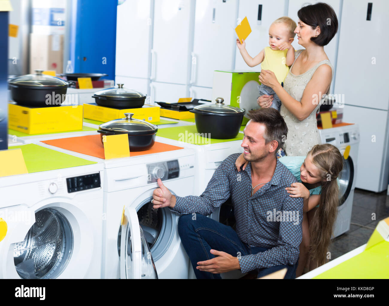 Glad family together choosing washing machine in shop of household ...