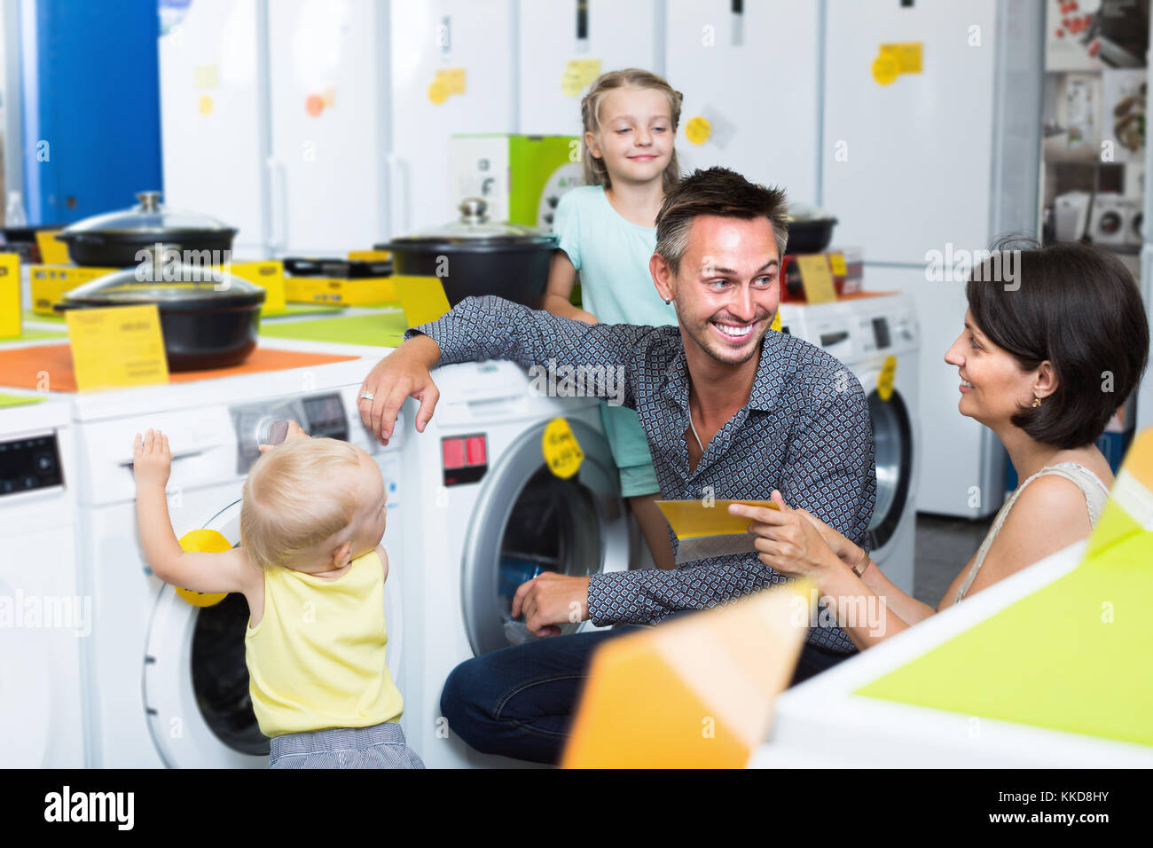 Smiling family of four shopping modern washer in household store Stock ...