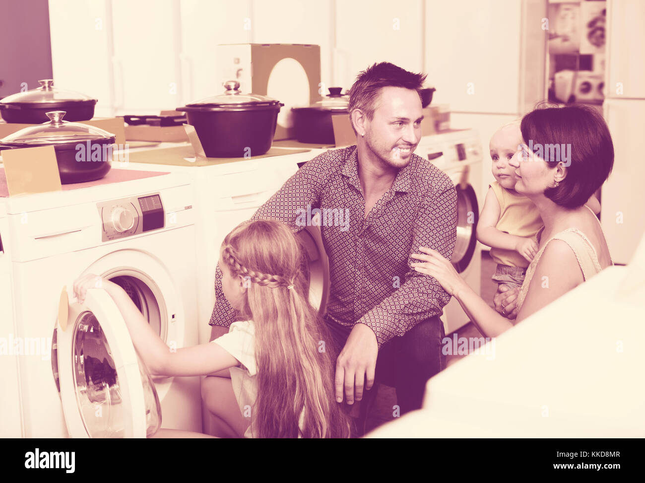 Young family with two kids together choosing washing machine in shop of ...