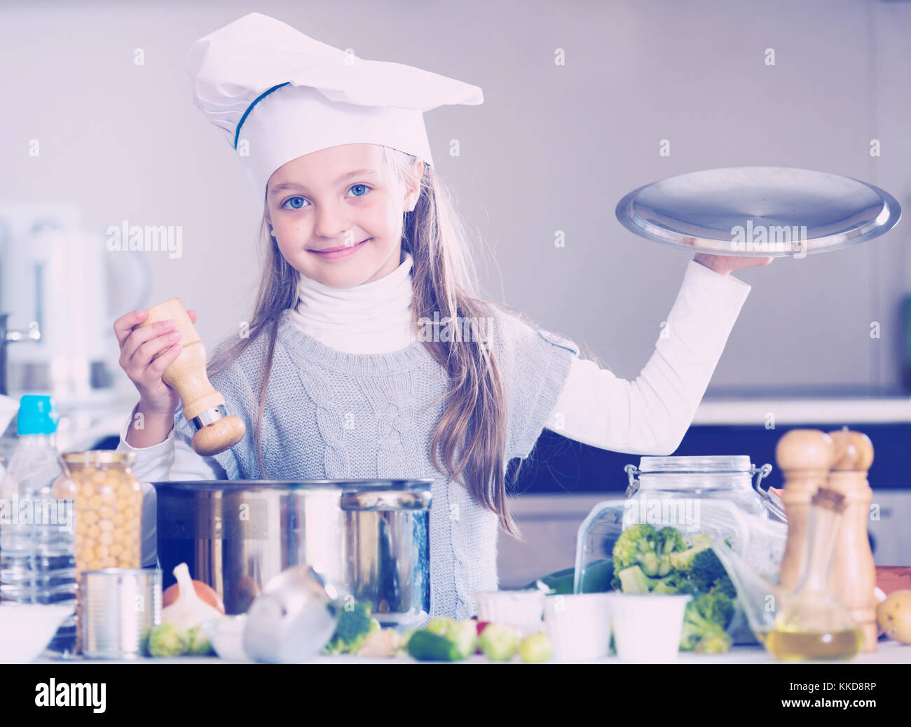 Happy little girl preparing soup for first course at home Stock Photo ...