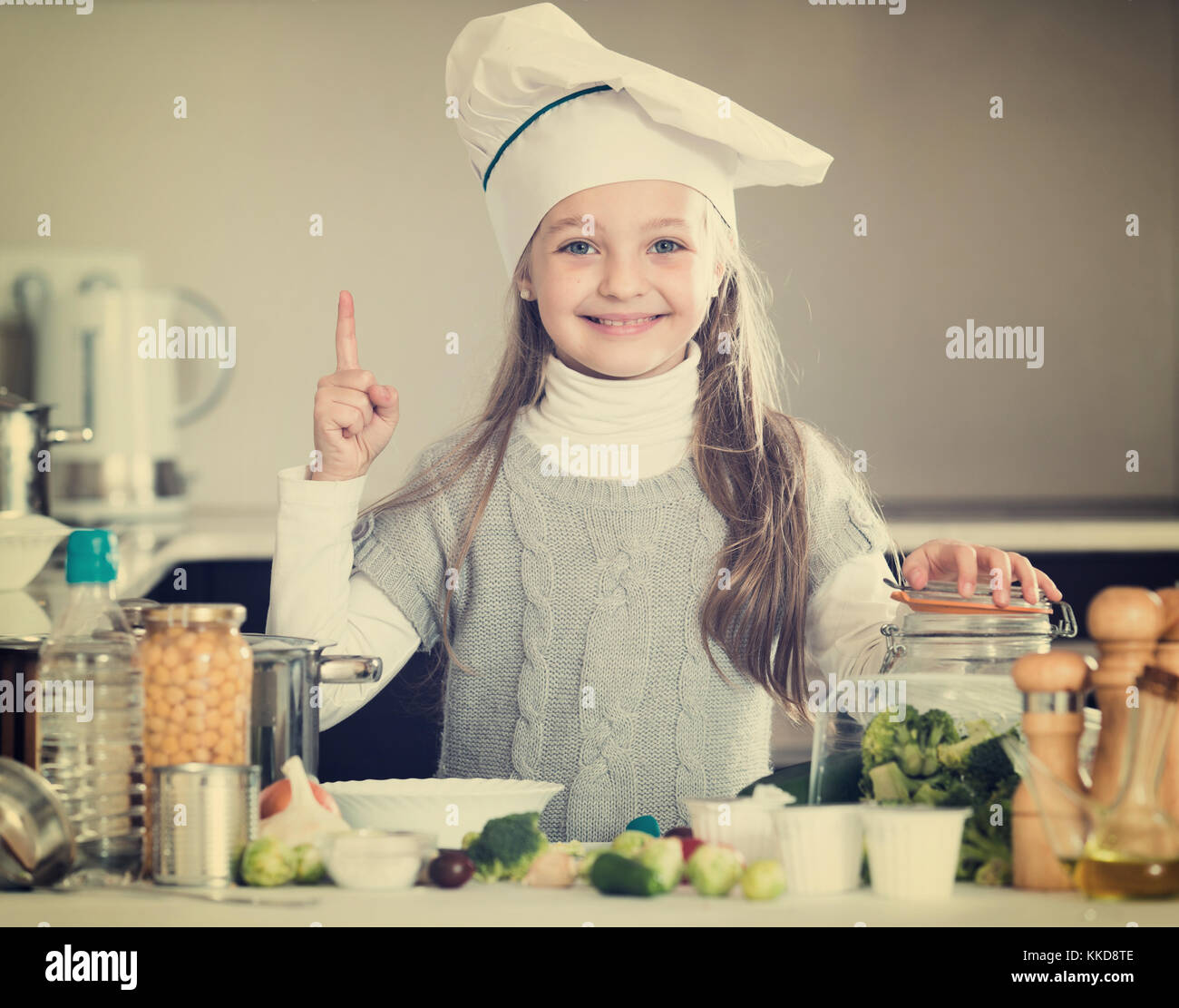 Portrait of cute little girl in cook cap cooking veggies Stock Photo ...