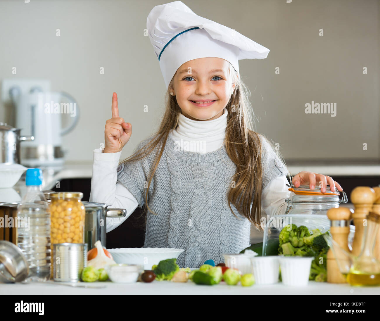 Portrait of cute little girl in cook cap cooking veggies Stock Photo ...