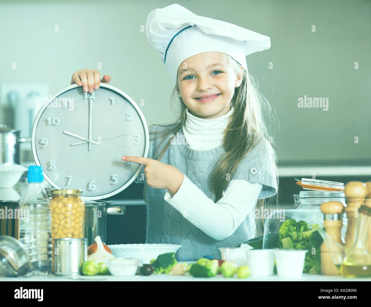 Portrait of cute little girl counting time down when cooking Stock ...