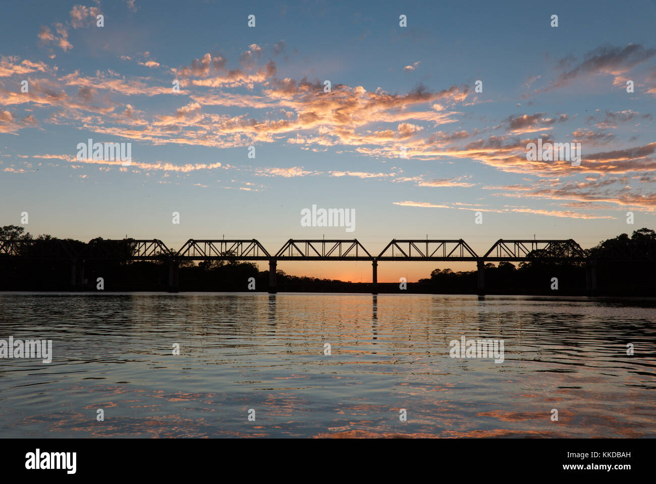 Sunset over the Burnett River and railway bridge at Bundaberg ...