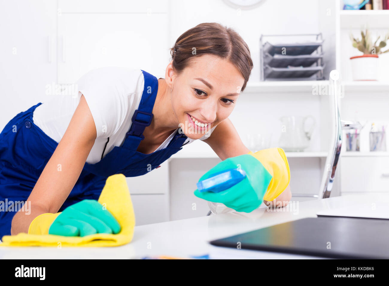 glad woman wearing bright uniform cleaning at company office Stock ...