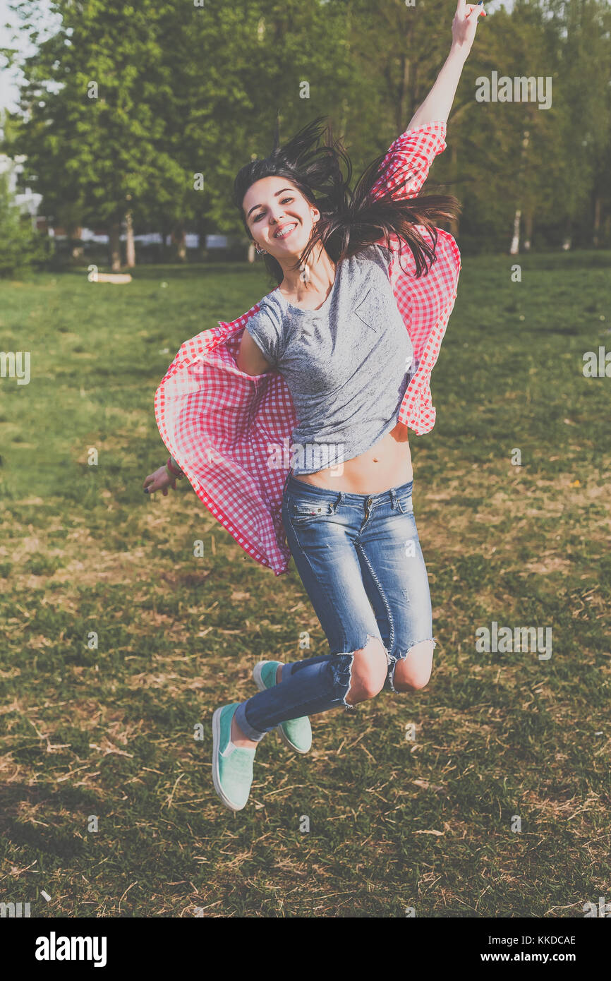 hipster woman jumping and smiling Stock Photo - Alamy