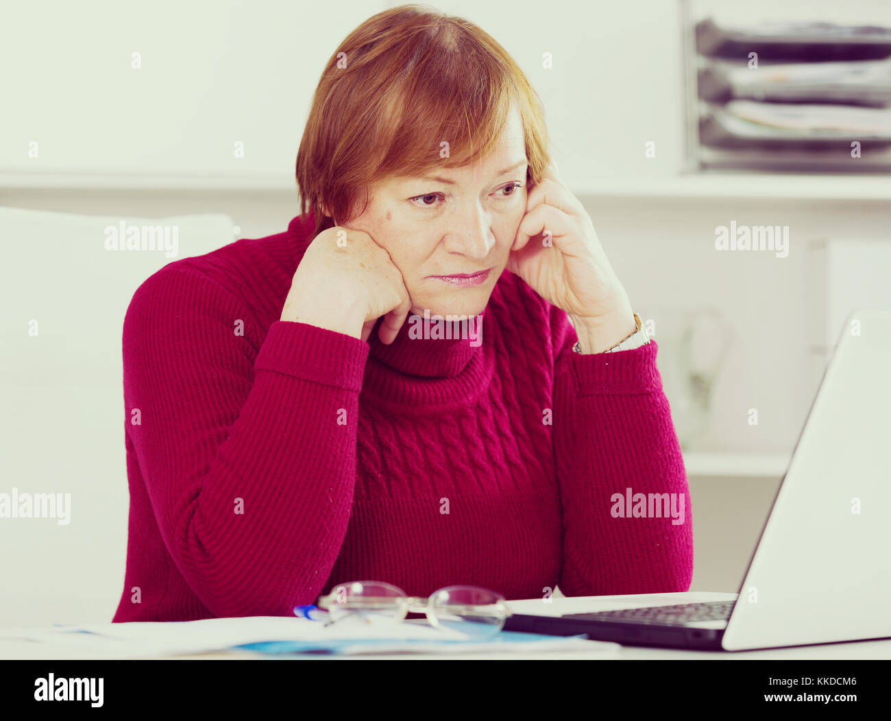 Aged woman worker facing challenge in project in office Stock Photo - Alamy