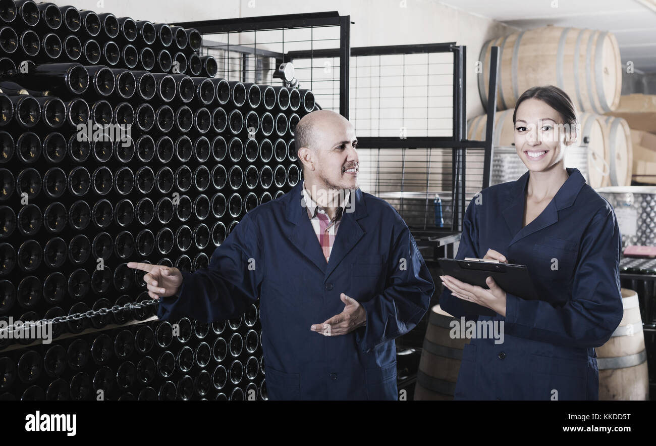 portrait of positive spanish expert woman standing with clipboard and ...