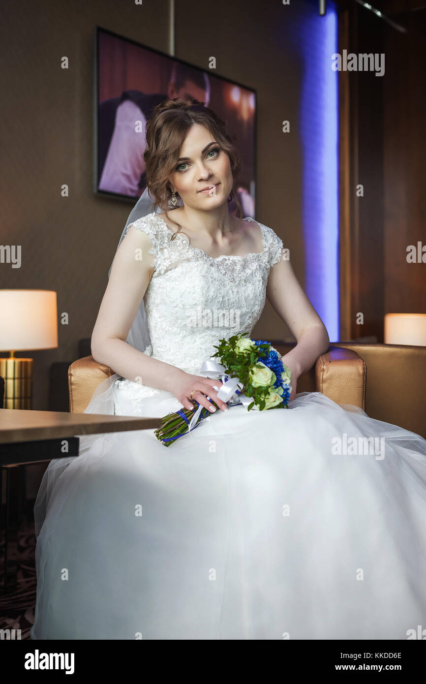 Young bride with wedding flowers sitting on the chair Stock Photo - Alamy